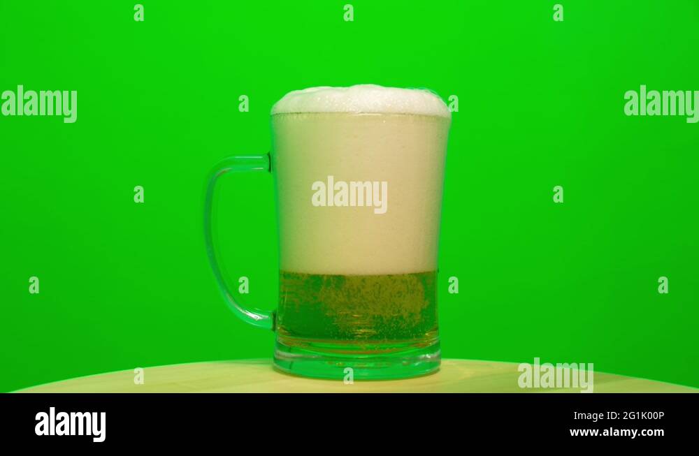 pour beer into a glass and take on the green screen background Stock ...