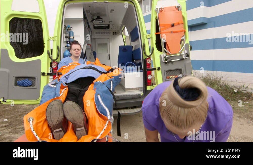 Emergency medical ambulance service paramedics fixing patient on ...