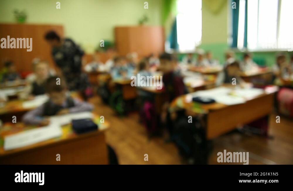 blurred background group of kids in a classroom at a school desk is a ...