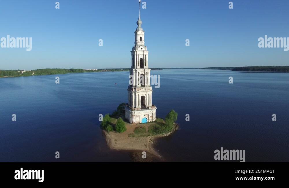 Old steeple sticking out in the middle of the river. Reflection in ...