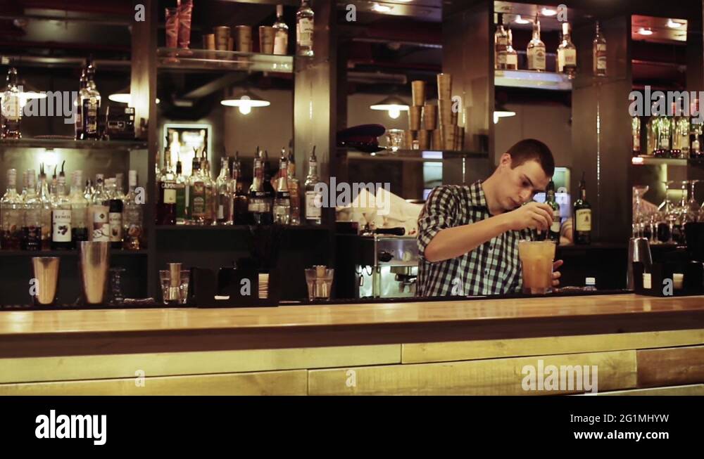 Young man working as a bartender in a nightclub bar Stock Video Footage ...
