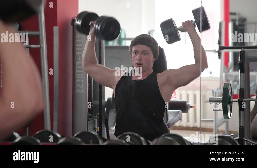 Man builds up muscles lifting a dumbbell in the gym Stock Video Footage ...