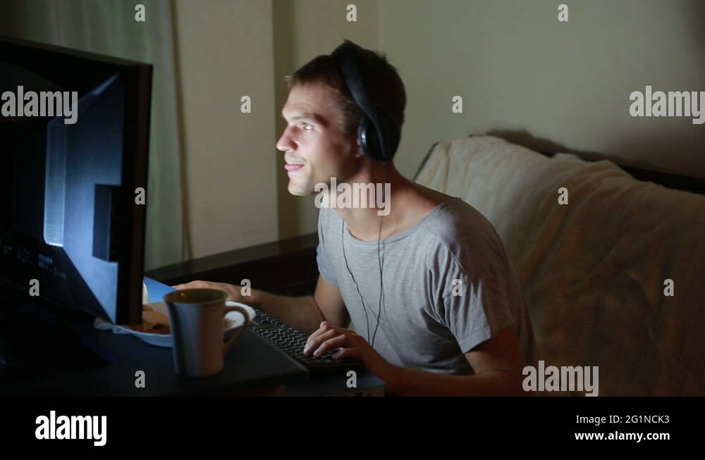 man playing video games on your computer. late at night on the computer ...