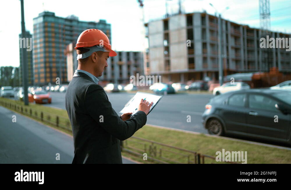 Construction worker. Architect look at paper plan of building Stock ...