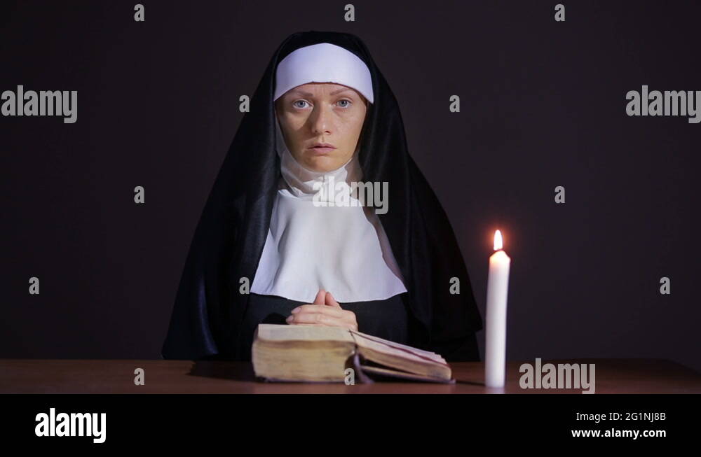 woman nun praying at night. burning candles. Woman in clothes nuns ...