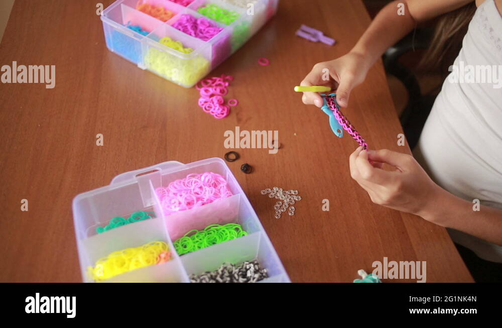 little girl weave wristband of rubber bands. Colored rubber bands for ...