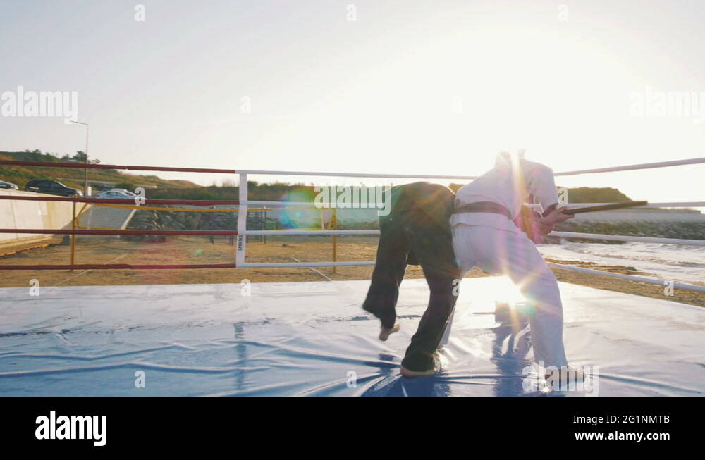 Two professional karate fighters are fighting on the beach boxing ring ...