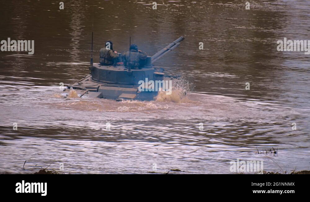 Armored military BMP and soldiers on the board are cross the river ...