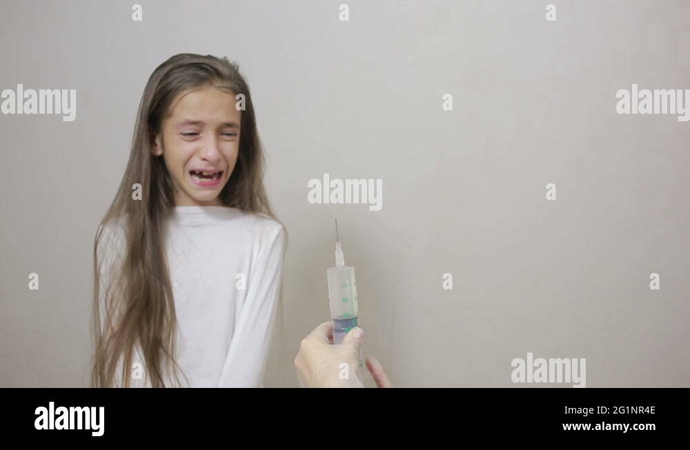 little girl is afraid of the doctor with a syringe. baby cries afraid ...
