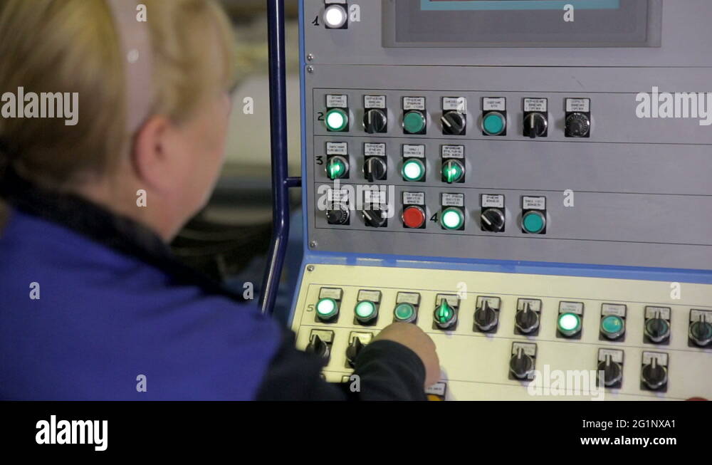 female worker operating industrial control panel, display at a modern ...
