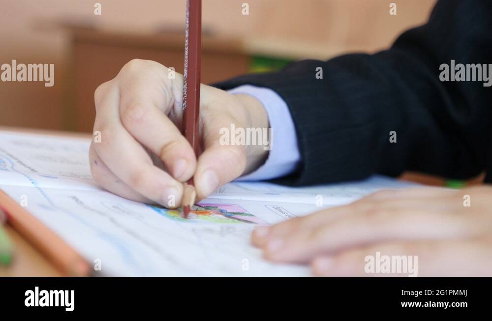 A schoolboy hand drawing pictures in an exercise book. Closeup Stock ...