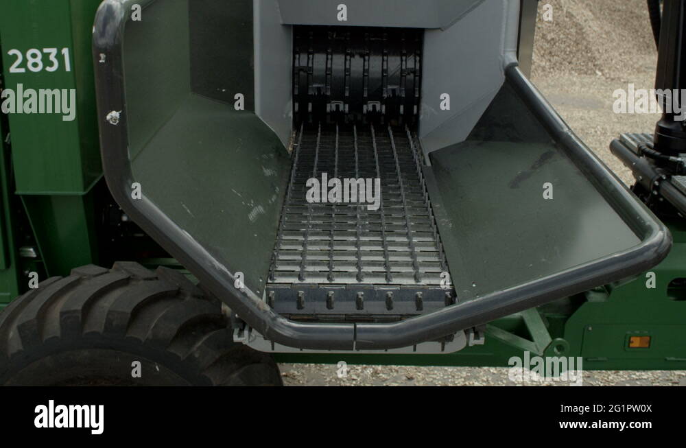 Wood chipping tractor overview, conveyor chain Stock Video Footage - Alamy
