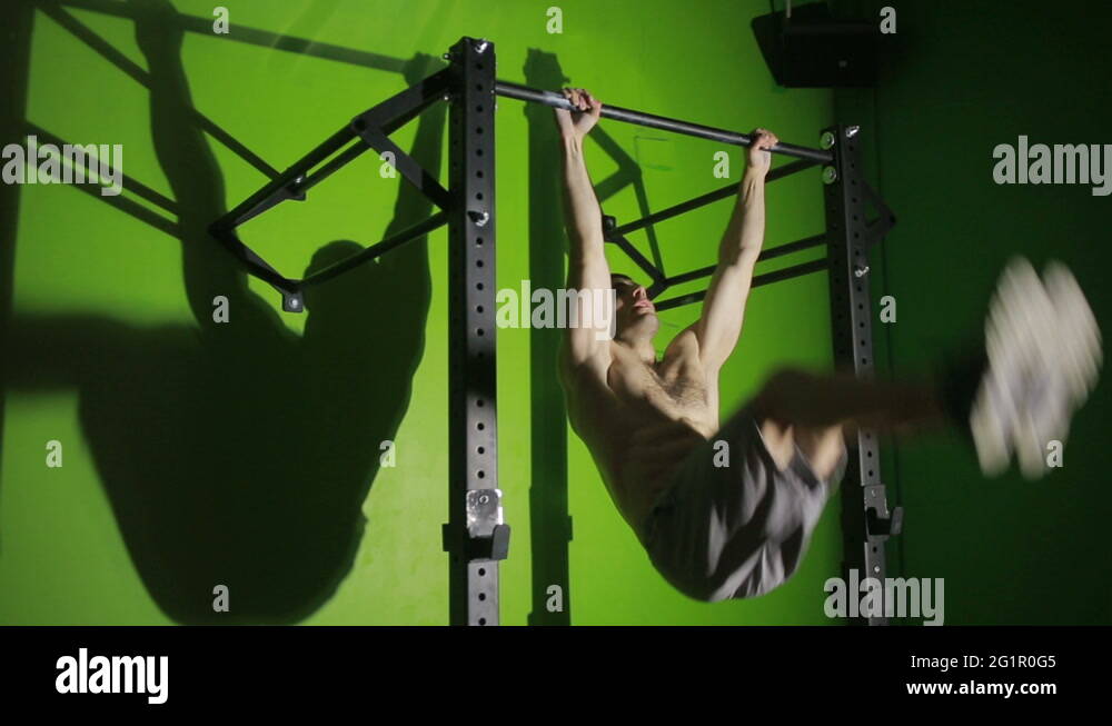 Shirtless man doing stomach exercises on a horizontal bar. CrossFit ...