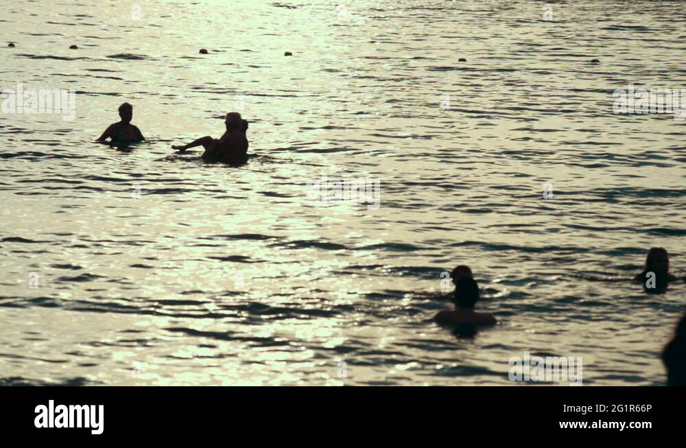 People swimming in the ocean silhouettes of people bathing in the sea ...