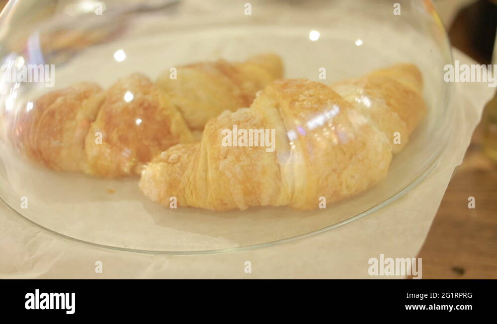 Croissants under a glass lid in a shop window. Desserts cafe Stock ...
