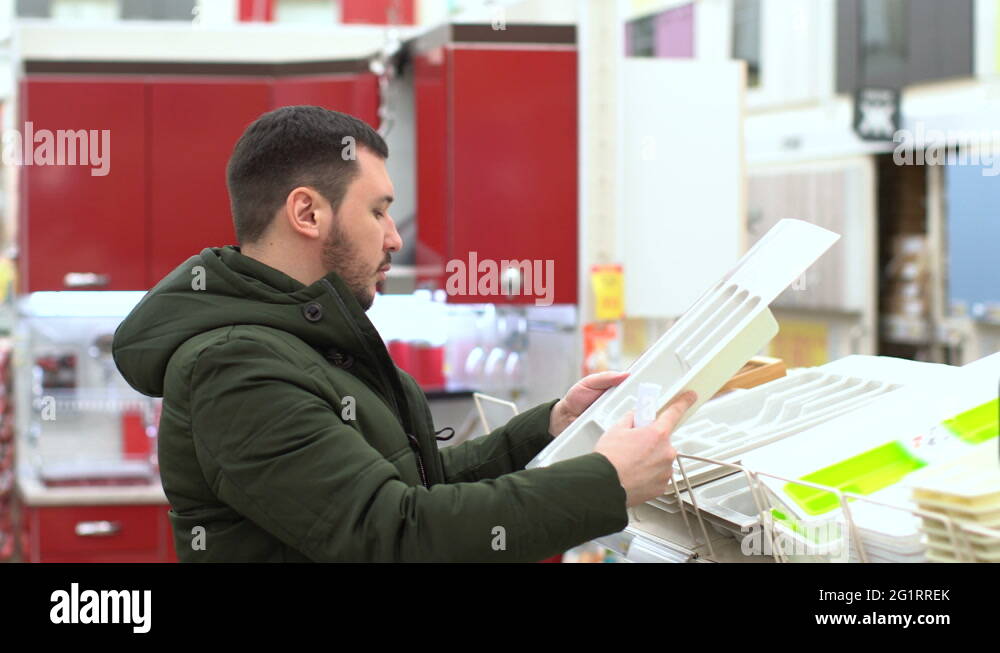 The adult young guy chooses the goods in the mall. People in-store ...
