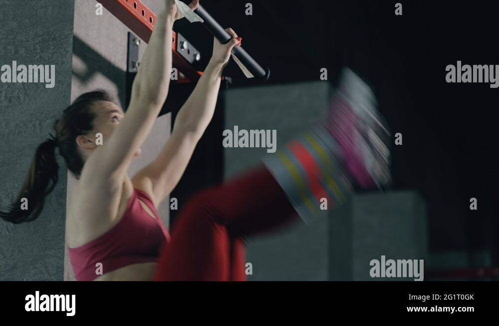 Strong woman pumping abdominal muscles hanging on horizontal bar Stock ...