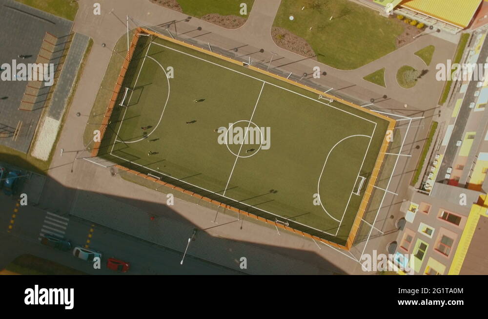 Above top view children play football soccer at school stadium aerial ...