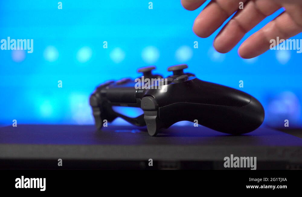 Sony PlayStation 4 slim game console DualShock 4 controller in front of ...