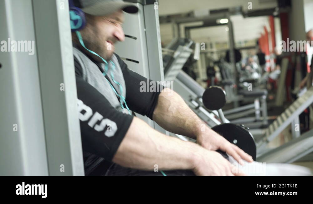Strong bodybuilder works out with simulator leg press in the gym Stock ...