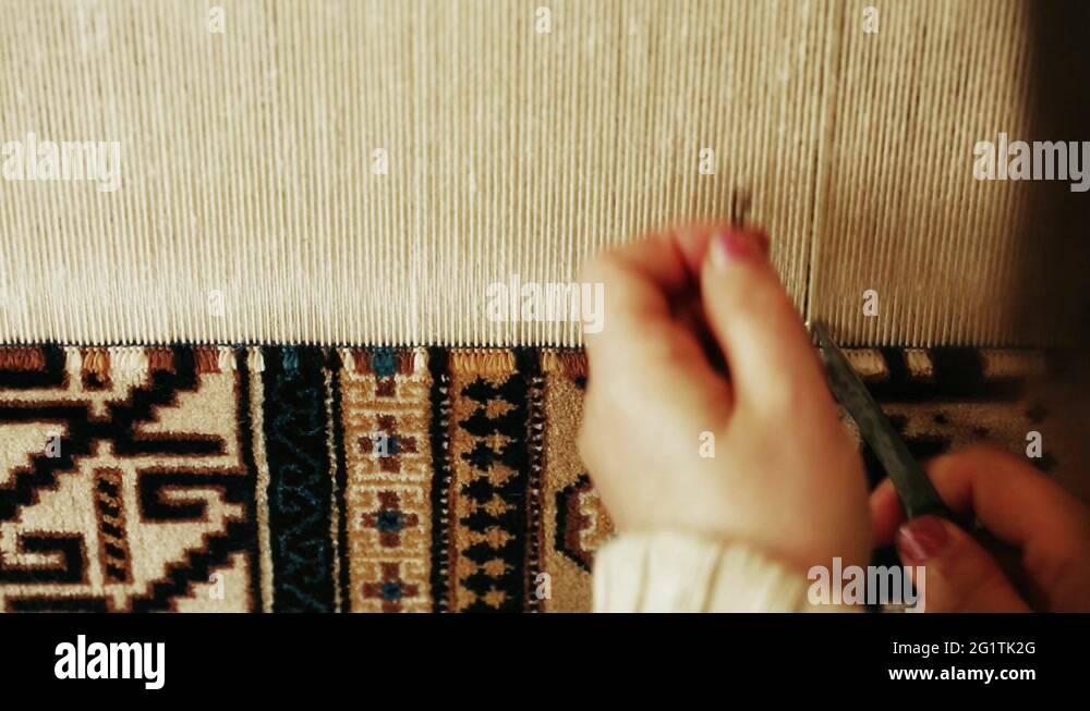 Carpet weaving. Turkish woman weaving a carpet with peace of genuine ...