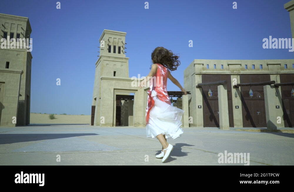 Little cute girl dances on the stage in amphitheatre. Child have a ...