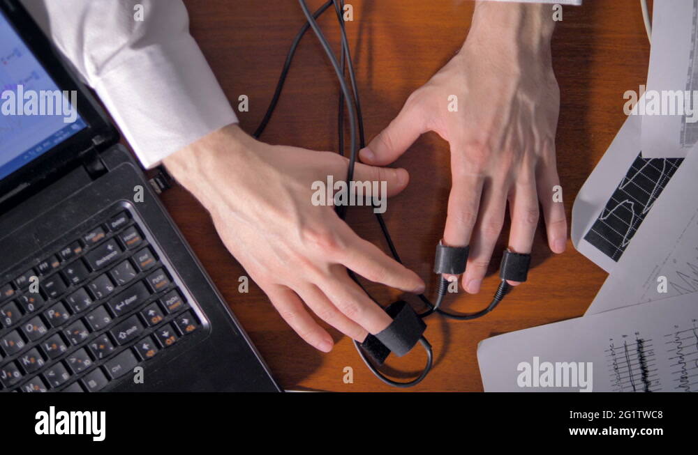 Polygraph test. Man's shaking hands and the laptop during lie detector ...