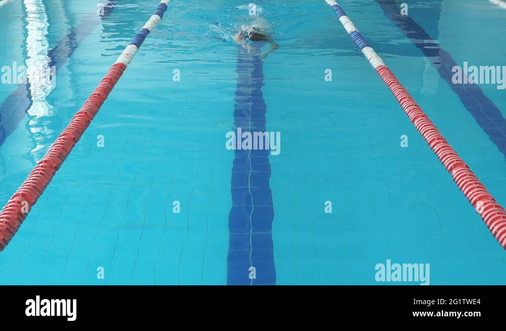 Fit swimmer girl jumping and cheering in swimming pool in slow motion ...