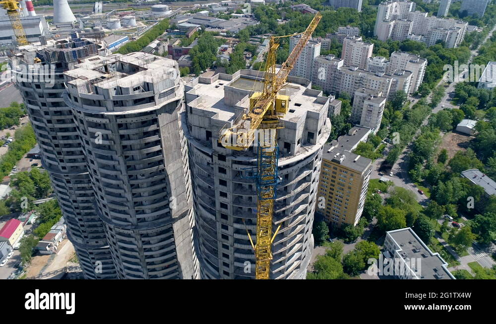Unfinished new tower blocks on a city urban background. Aerial, 4K ...