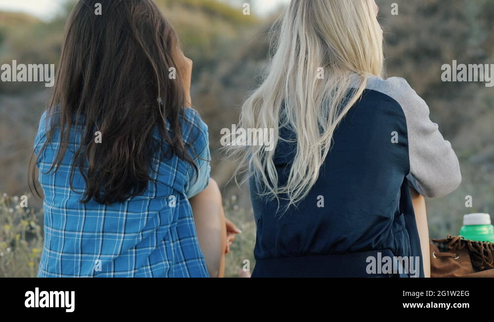 Best friends hiking together. Two young women sitting on nature, back ...