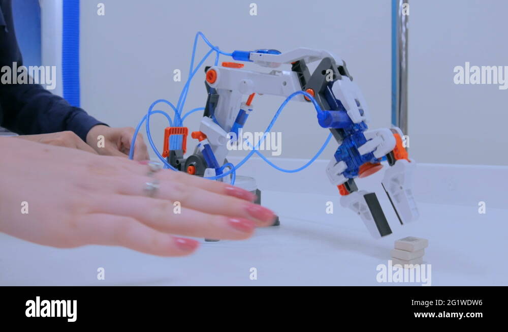 Woman controls robot hand manipulator at technology exhibition Stock ...