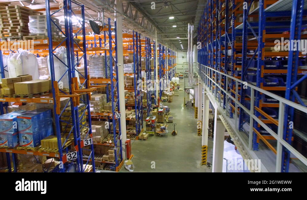 Camera goes between warehouse shelves in a modern storehouse with many ...
