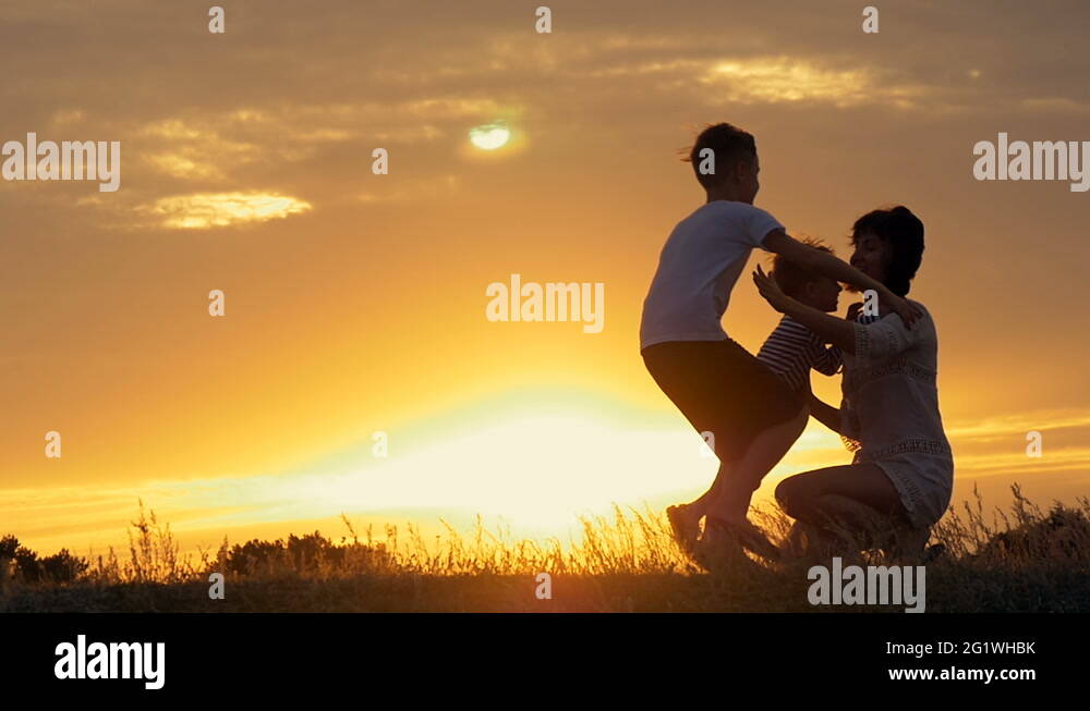 silhouette of happy children running into the arms of a loving mother ...