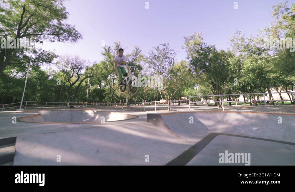 BMX rider doing trick in extreme park and falling down, slow motion ...