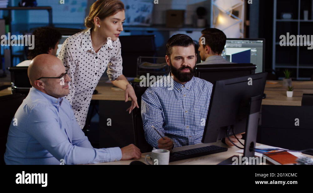 Two office co-workers talking about their new project and demonstrating ...