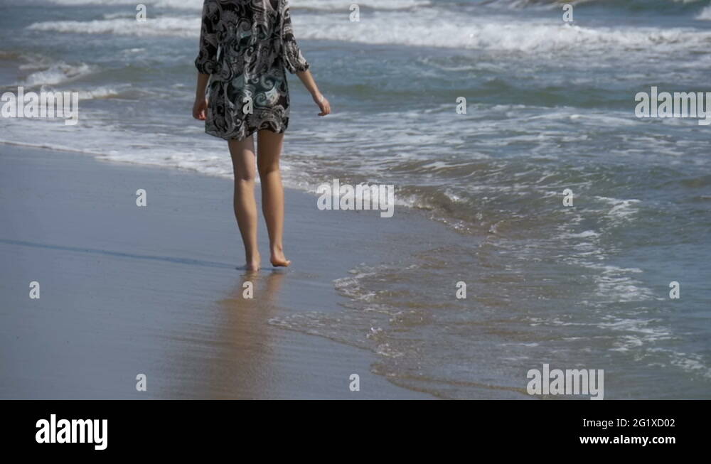 Girl in bathing suit runs along the sea shore at the beach in Slow ...