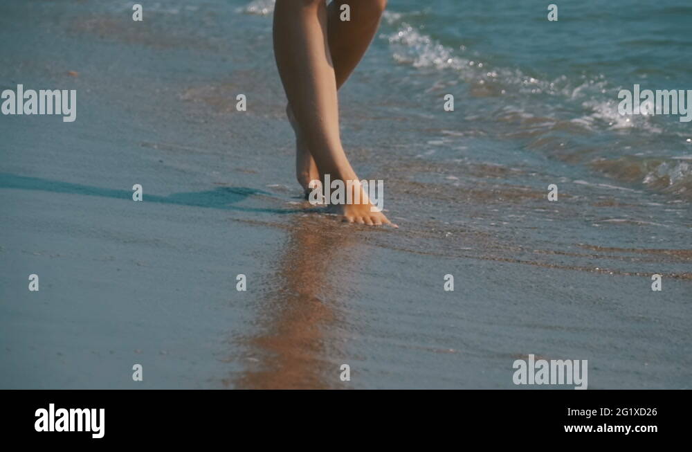 Girl in bathing suit runs along the sea shore at the beach in Slow ...