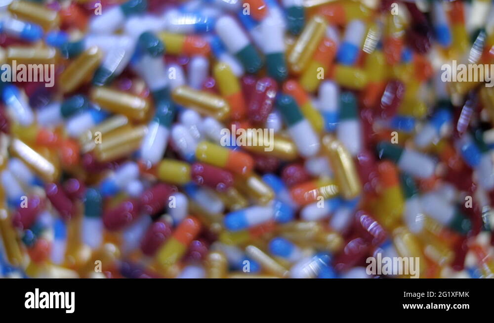 Сolorful capsules of the medication is rotate on a table Stock Video ...