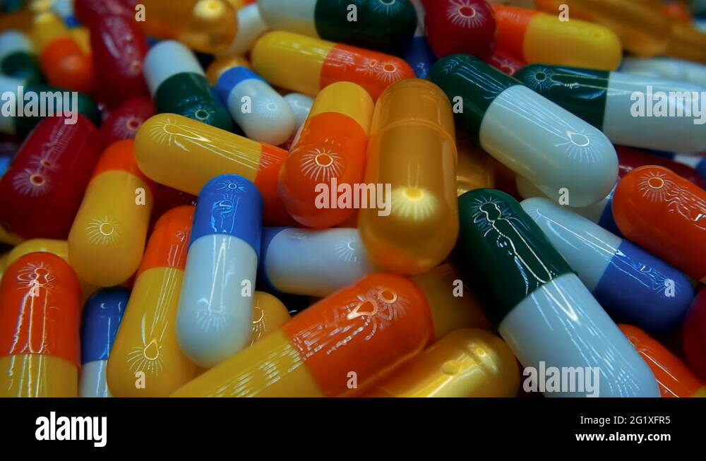 Сolorful capsules of the medication is rotate on a table Stock Video ...