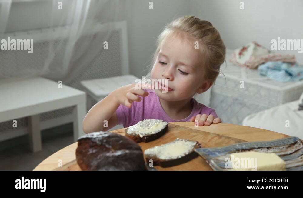 Cute little girl leak butter from sandwich Stock Video Footage - Alamy