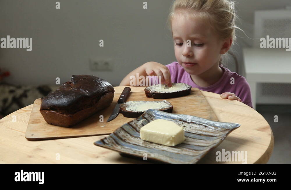 Cute little girl leak butter from sandwich Stock Video Footage - Alamy