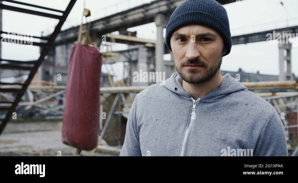 Portrait of the young angry male boxer looking at the red bag and than ...