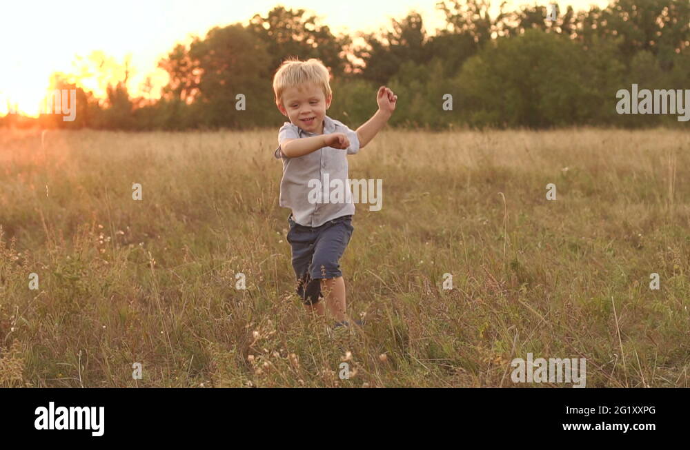 Beautiful little boy running through a field Stock Video Footage - Alamy