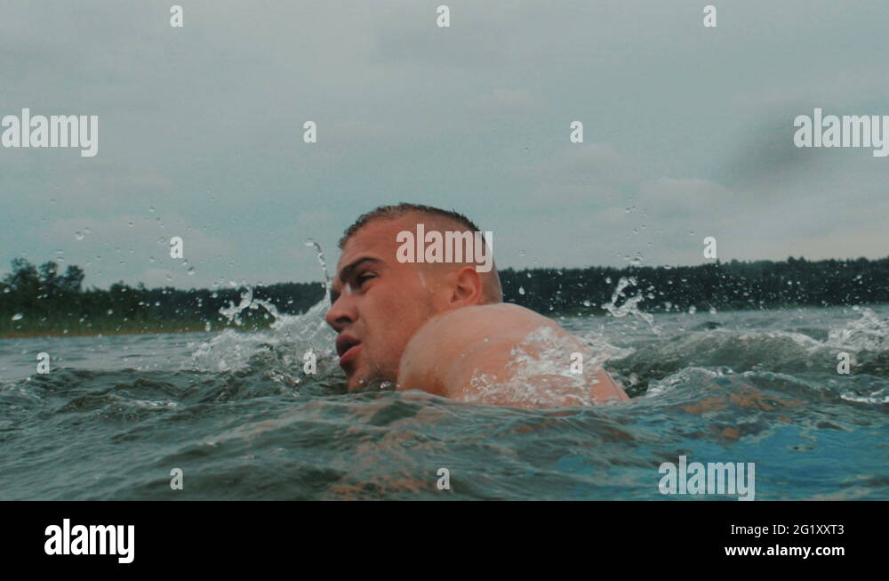 4k of Muscular male swimming at the lake, back view Stock Video Footage ...