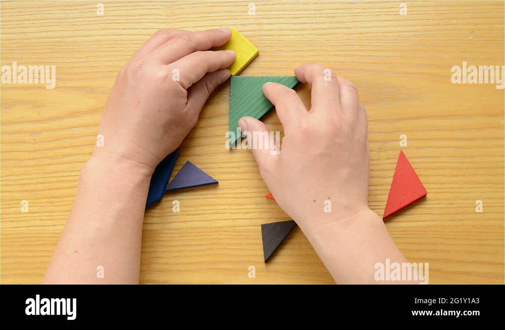 man playing wooden tangram and making different shapes of human 3 of 3 ...