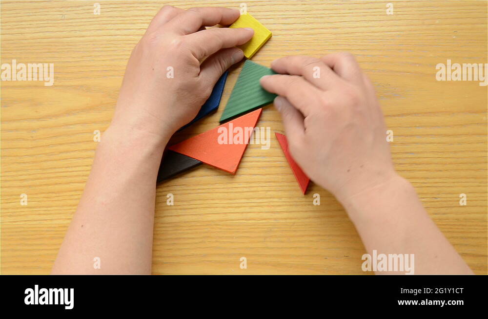 man playing wooden tangram and making different shapes of human 1 of 3 ...