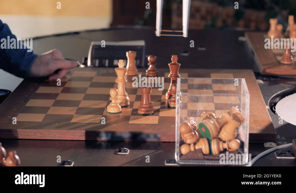 Robot playing chess with a man. Hand manipulator moves the chess and ...