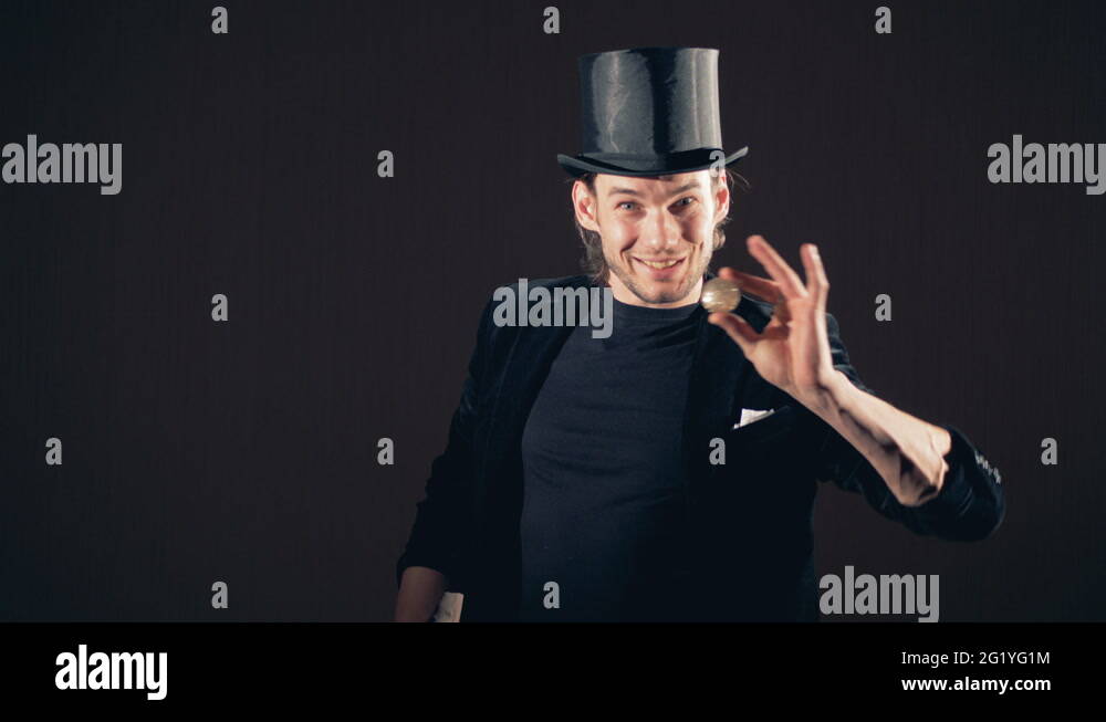 An illusionist is showing a conjuring trick with a little sparkling ...