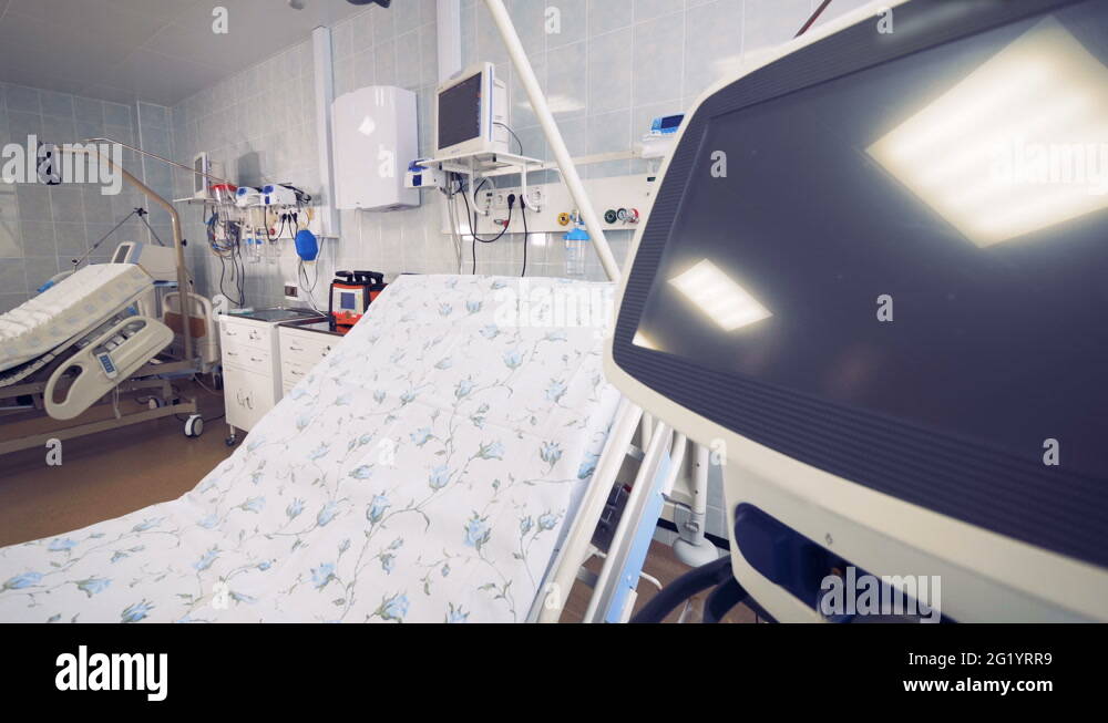 Side view of a fully-equipped hospital ward with a focus on a bed and a ...
