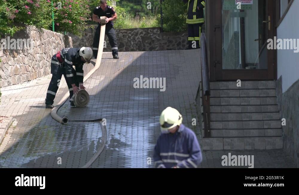 Firefighters rolling up a fire hose Stock Video Footage - Alamy
